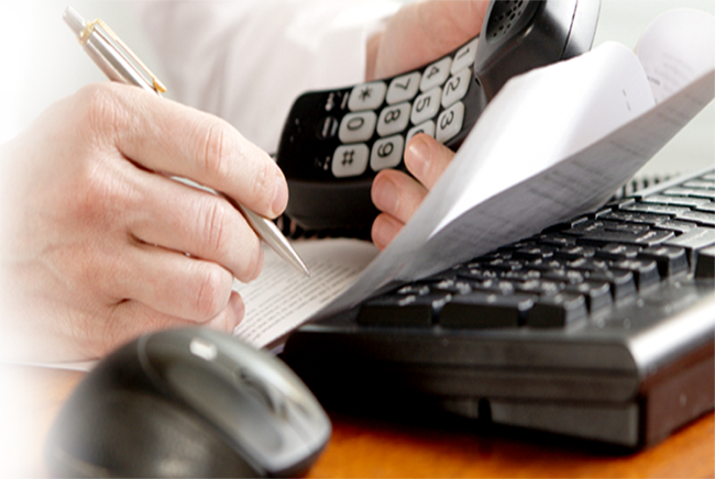 Photo of hands holding both a phone and pen - filling out document in ...